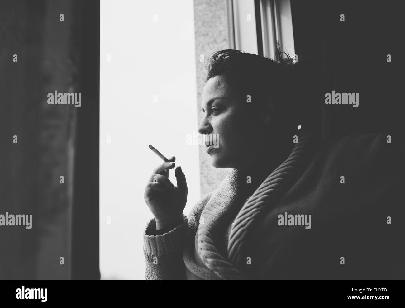 Woman smoking by window hi-res stock photography and images - Alamy