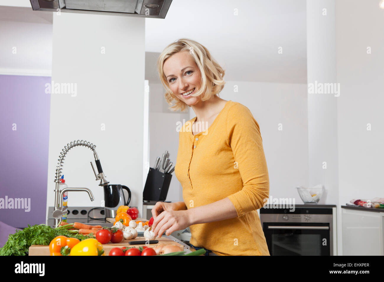 Smiling woman cooking in kitchen Stock Photo - Alamy