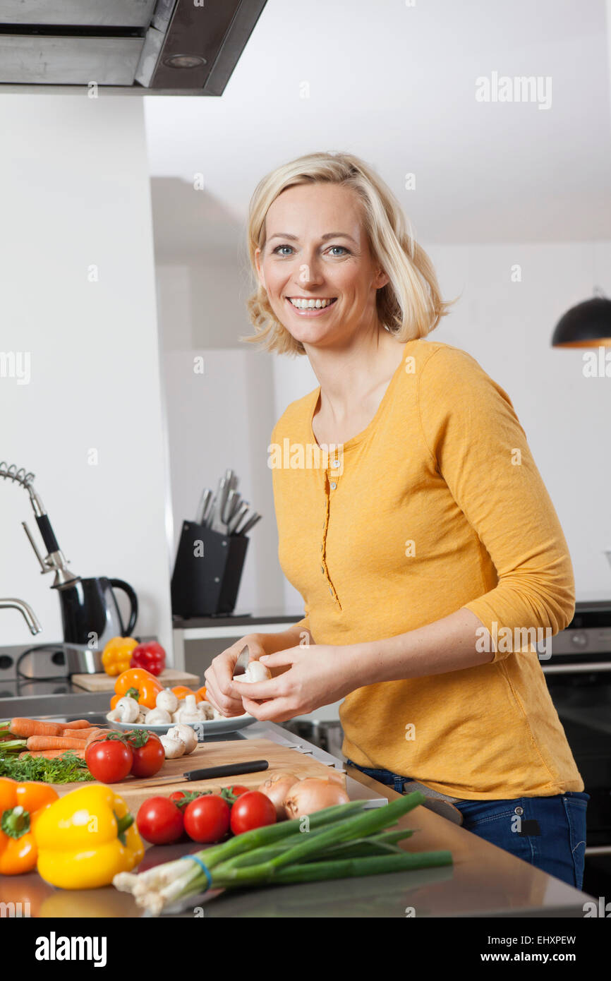 Smiling woman cooking in kitchen Stock Photo - Alamy