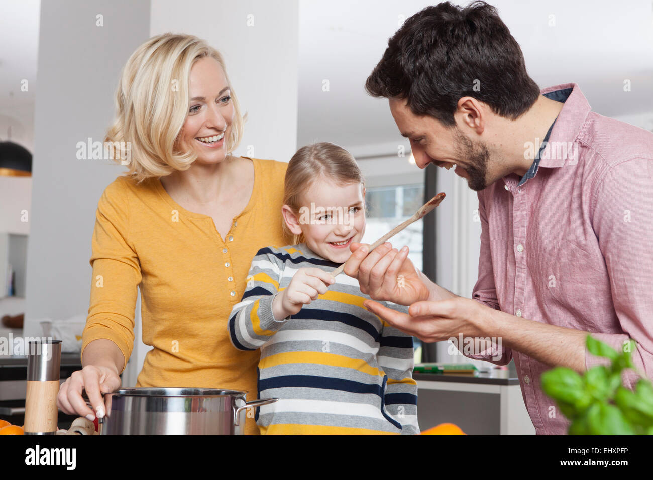 Mother, father and daughter cooking in kitchen Stock Photo - Alamy
