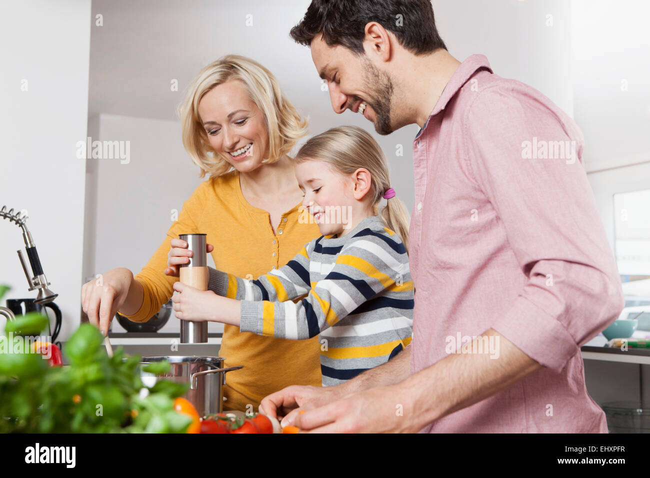 Mother, father and daughter cooking in kitchen Stock Photo - Alamy