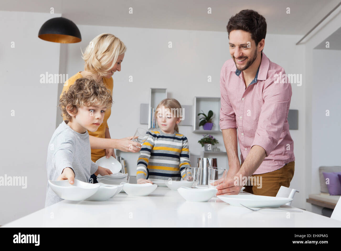 Family laying the table Stock Photo - Alamy