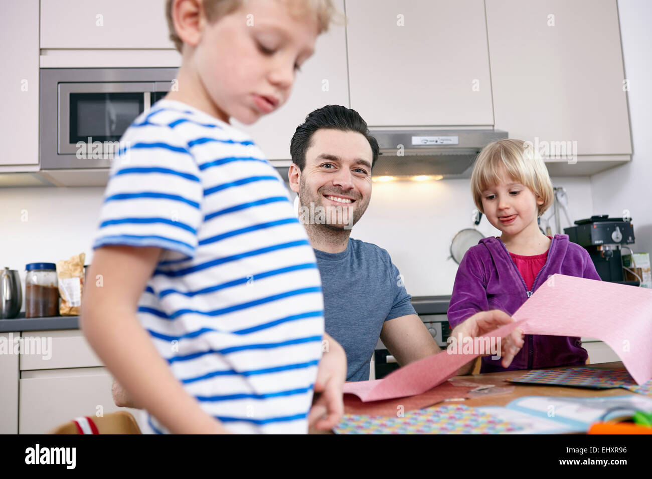 Father tinkering in kitchen with son and daughter Stock Photo - Alamy