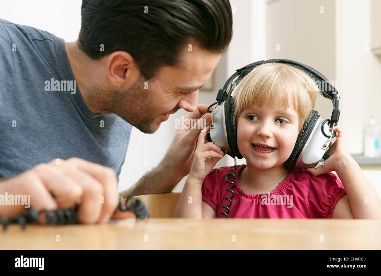 Father and daughter listening to music with headphones Stock Photo - Alamy