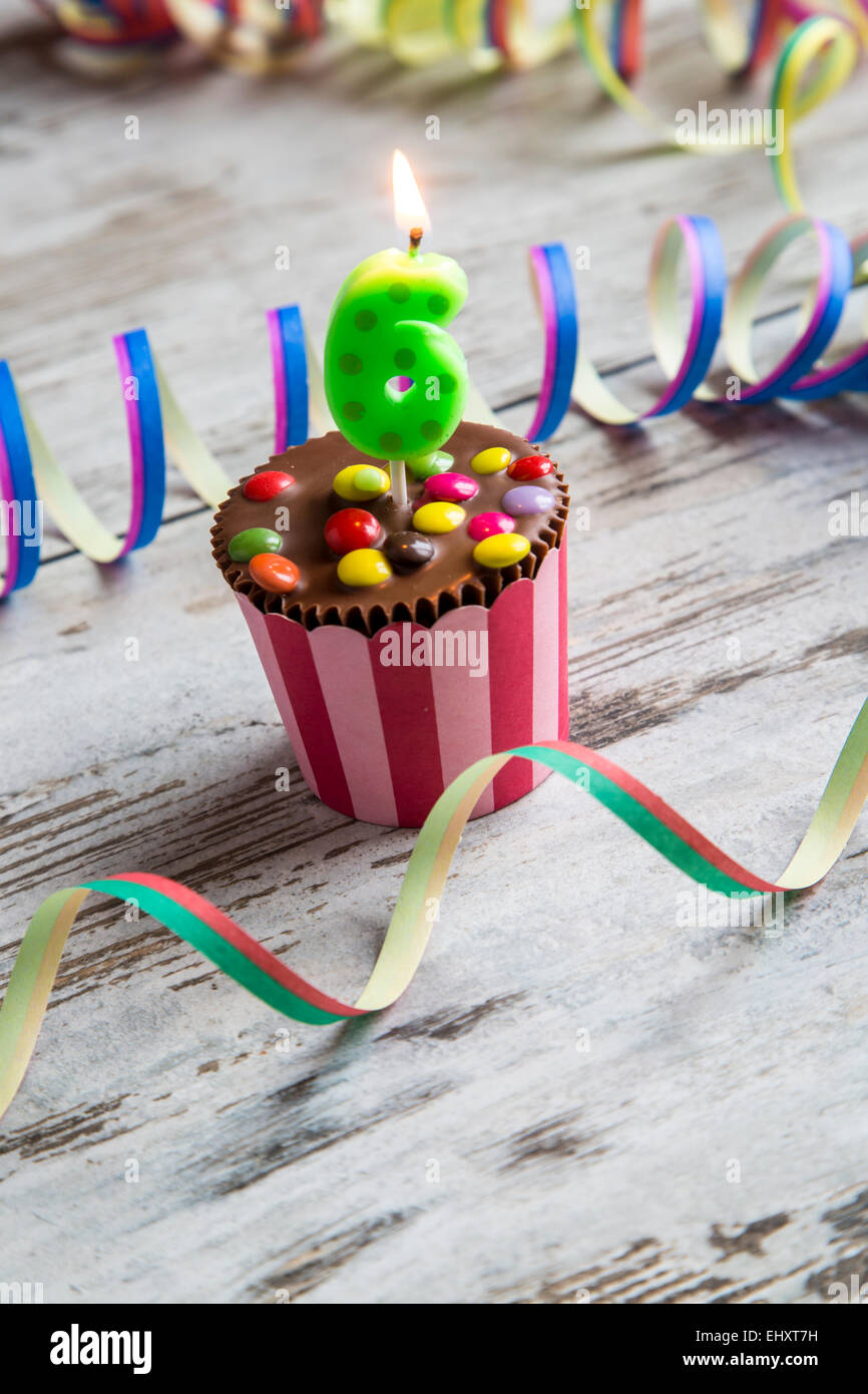Birthday muffin with chocolate buttons and lighted candle Stock Photo ...