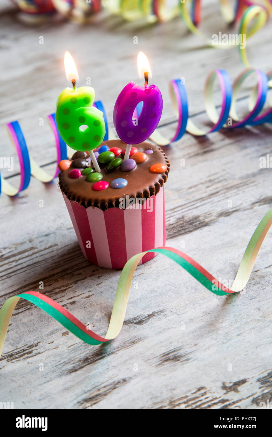 Birthday muffin with chocolate buttons and lighted candles Stock Photo ...
