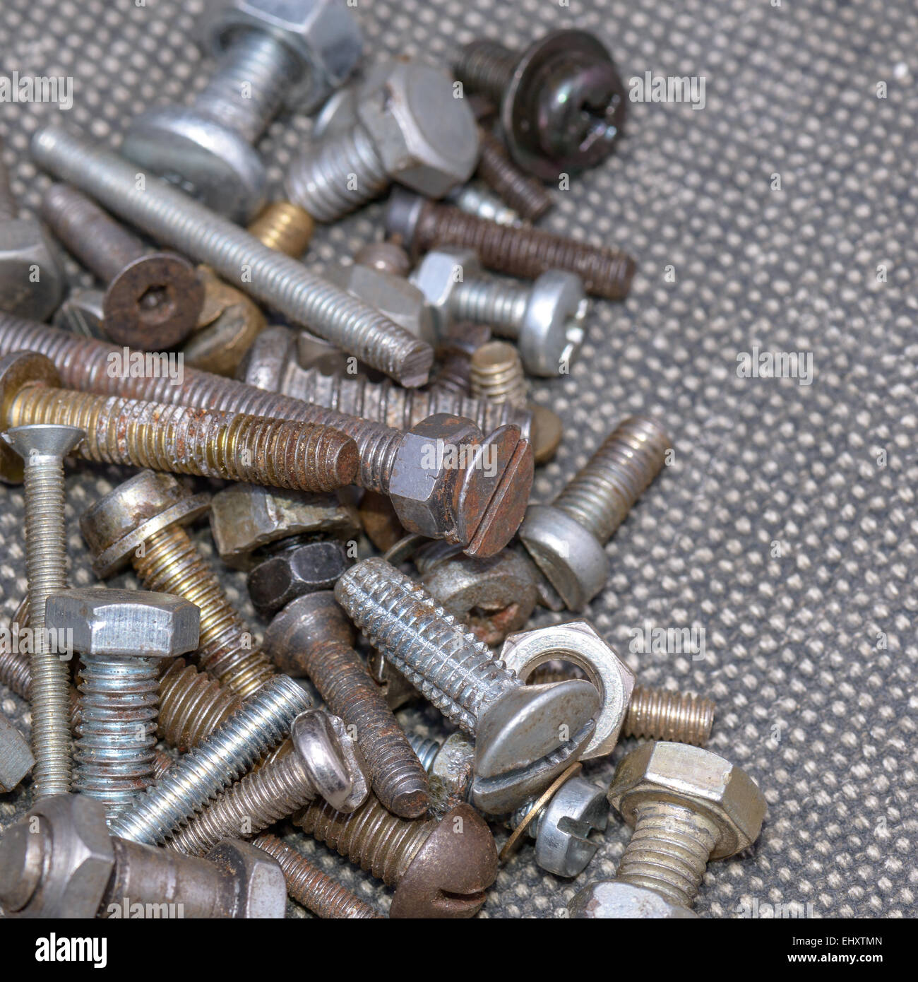 Several old screws on a grey texile background Stock Photo - Alamy