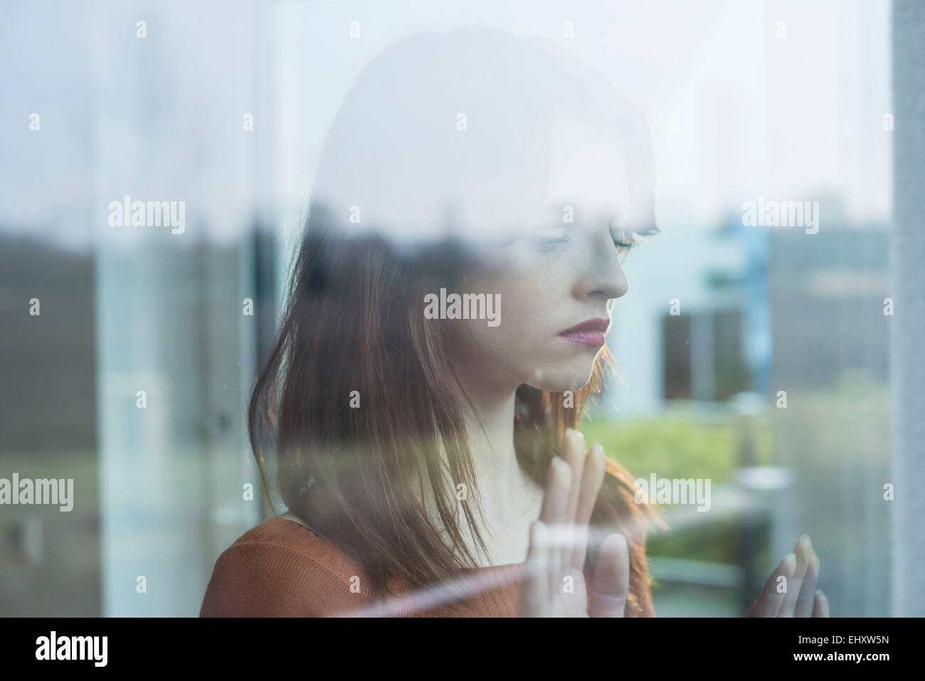 Young sad woman behind window hi-res stock photography and images - Alamy