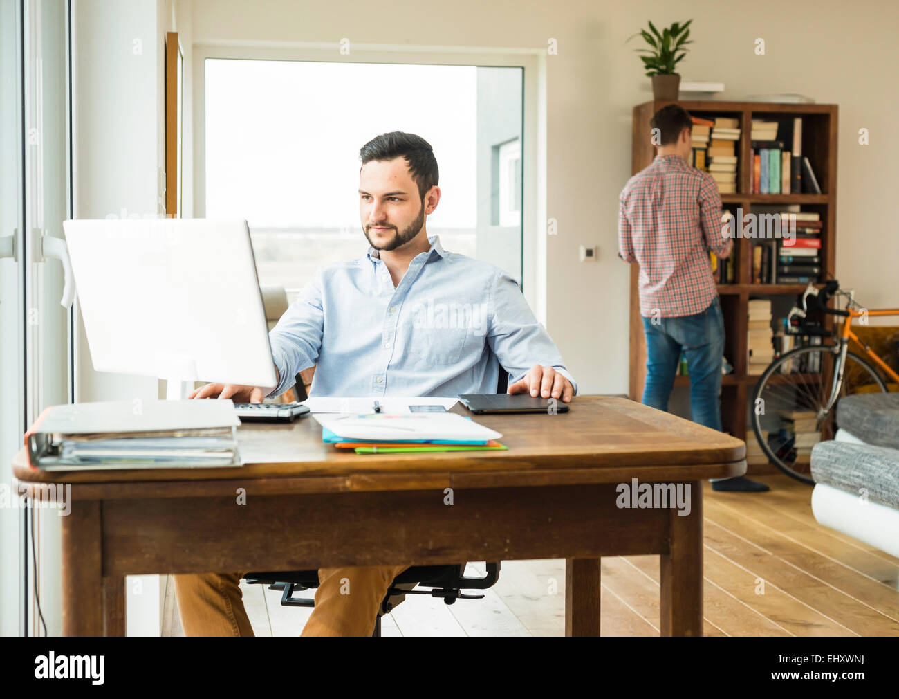 Young man working at computer at home Stock Photo - Alamy