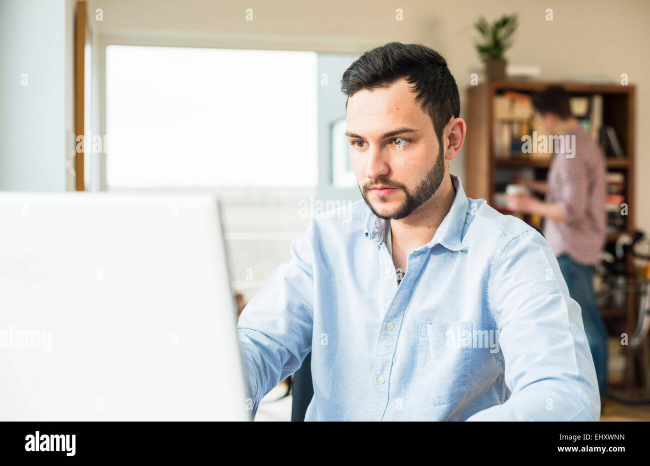 Young man working at computer at home Stock Photo - Alamy