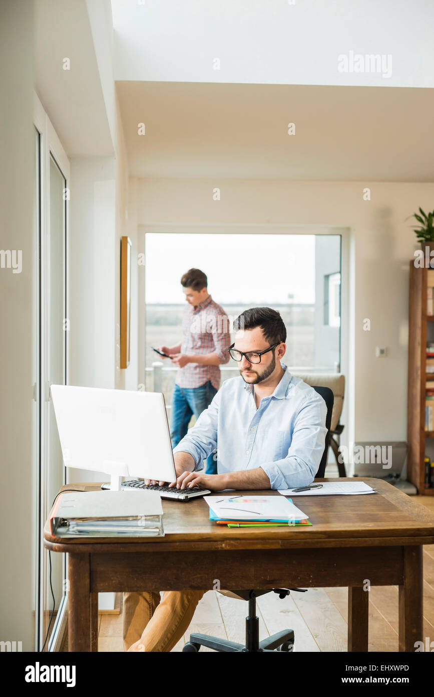 Young man working at computer at home Stock Photo - Alamy