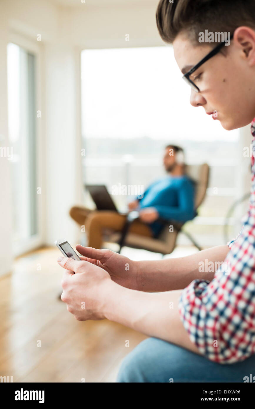 Young man looking at cell phone Stock Photo - Alamy