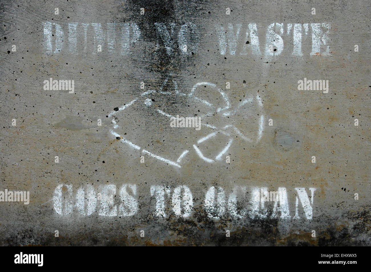 Weathered 'dump no waste goes to ocean' warning sign on concrete Stock ...