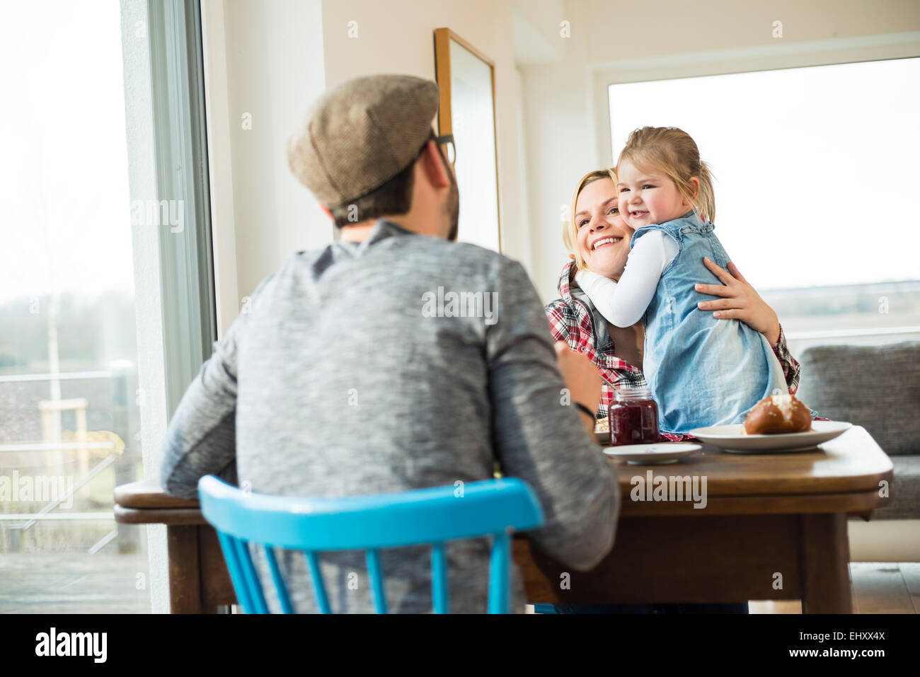 Happy family eating at dining table Stock Photo - Alamy