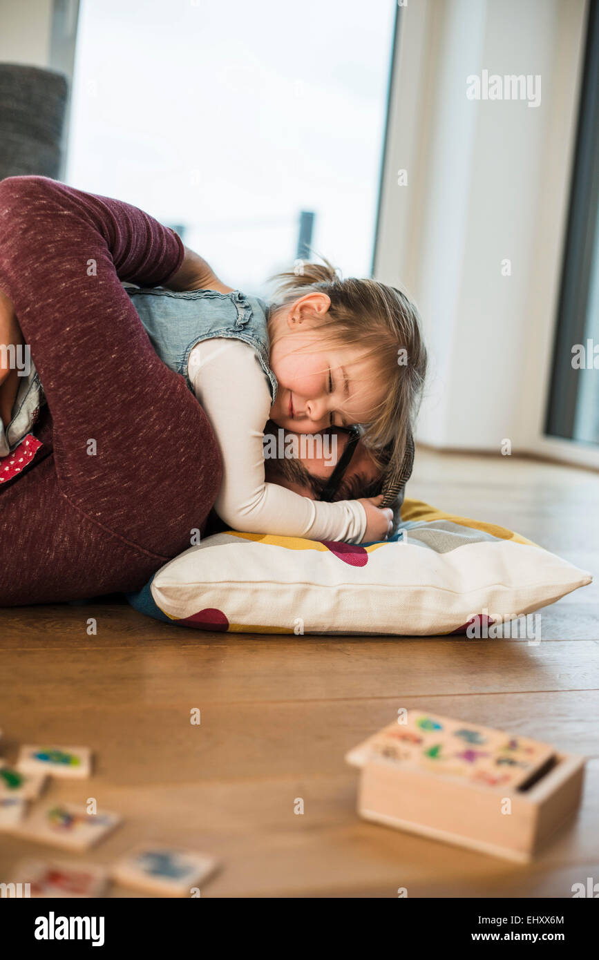 Father and daughter hugging on floor Stock Photo - Alamy