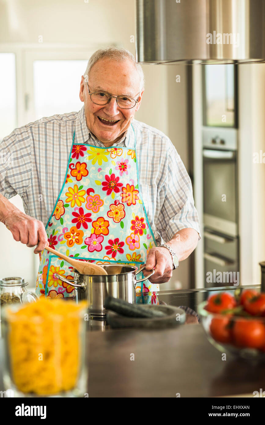 Happy senior man cooking in kitchen Stock Photo - Alamy