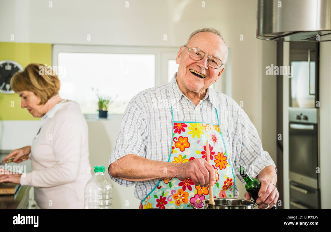 Happy senior man cooking in kitchen Stock Photo - Alamy
