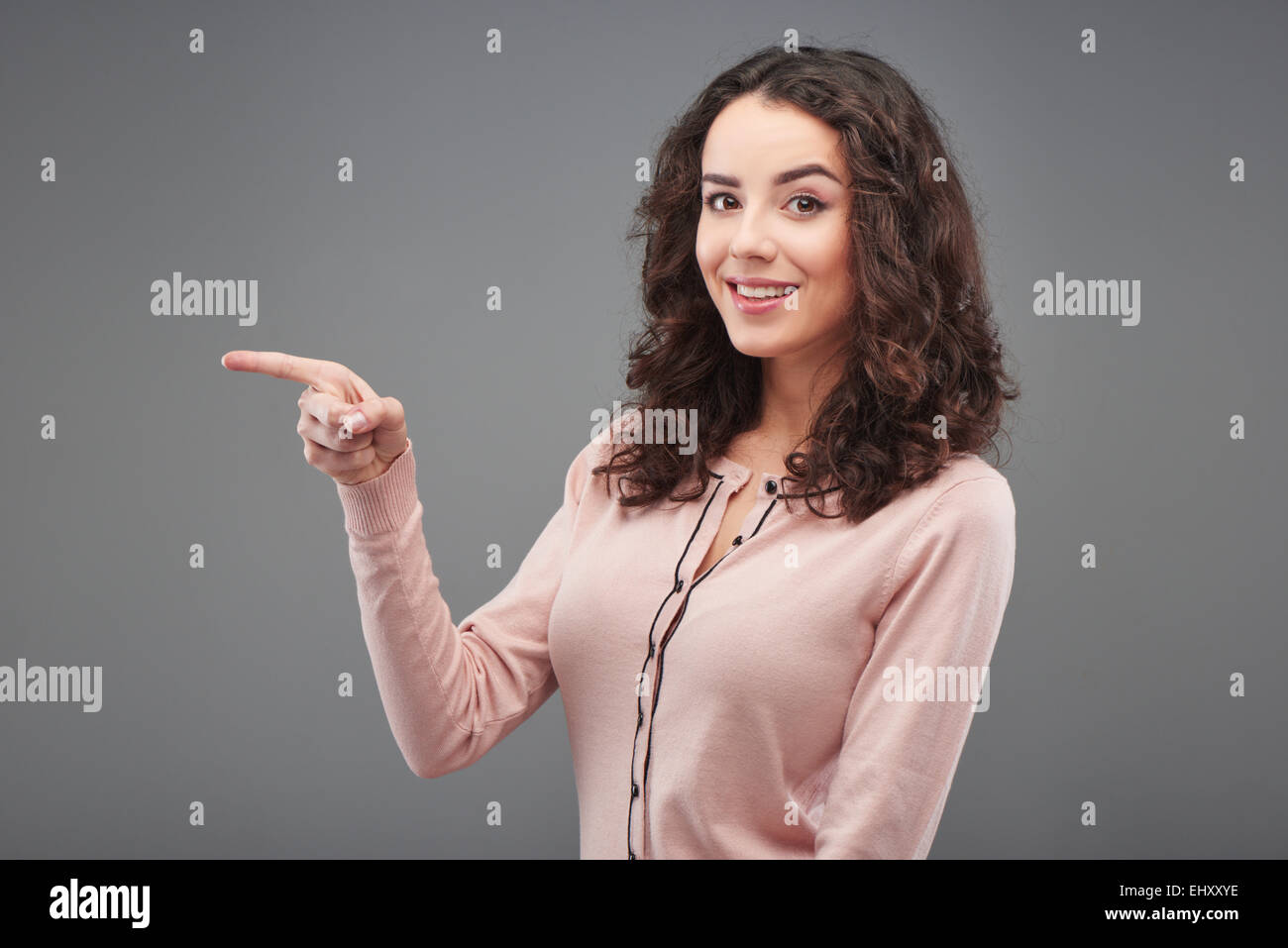 Beautiful young woman pointing at something Stock Photo - Alamy
