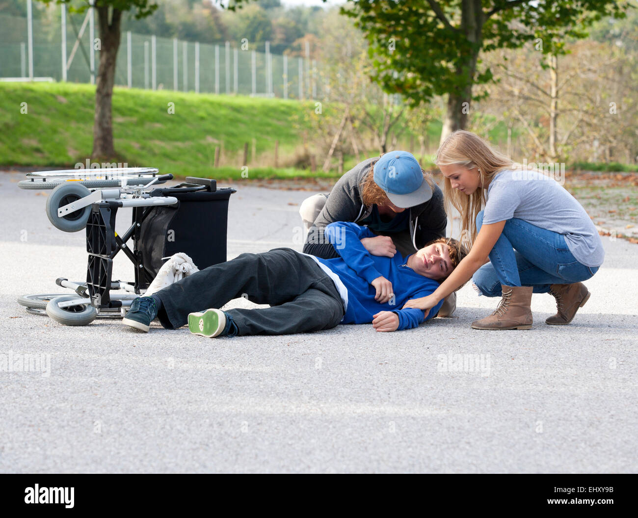 Two young people assisting young wheelchair user after fall Stock Photo ...