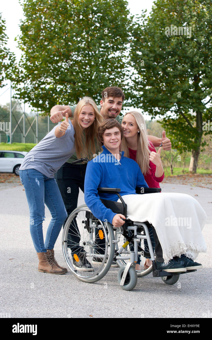 Young man in wheelchair with friends Stock Photo - Alamy