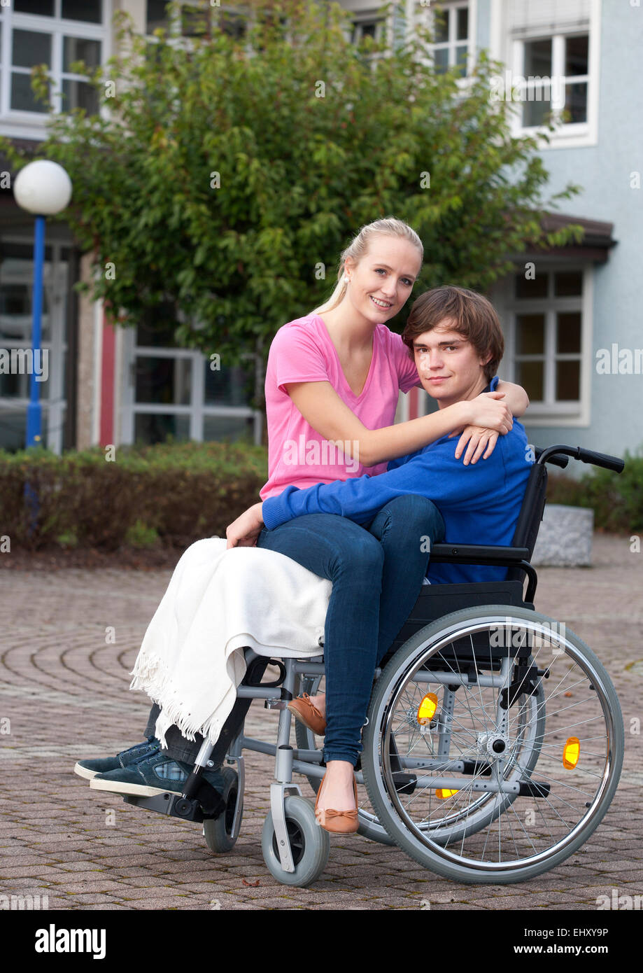Young woman embracing her boyfriend sitting in wheelchair Stock Photo ...