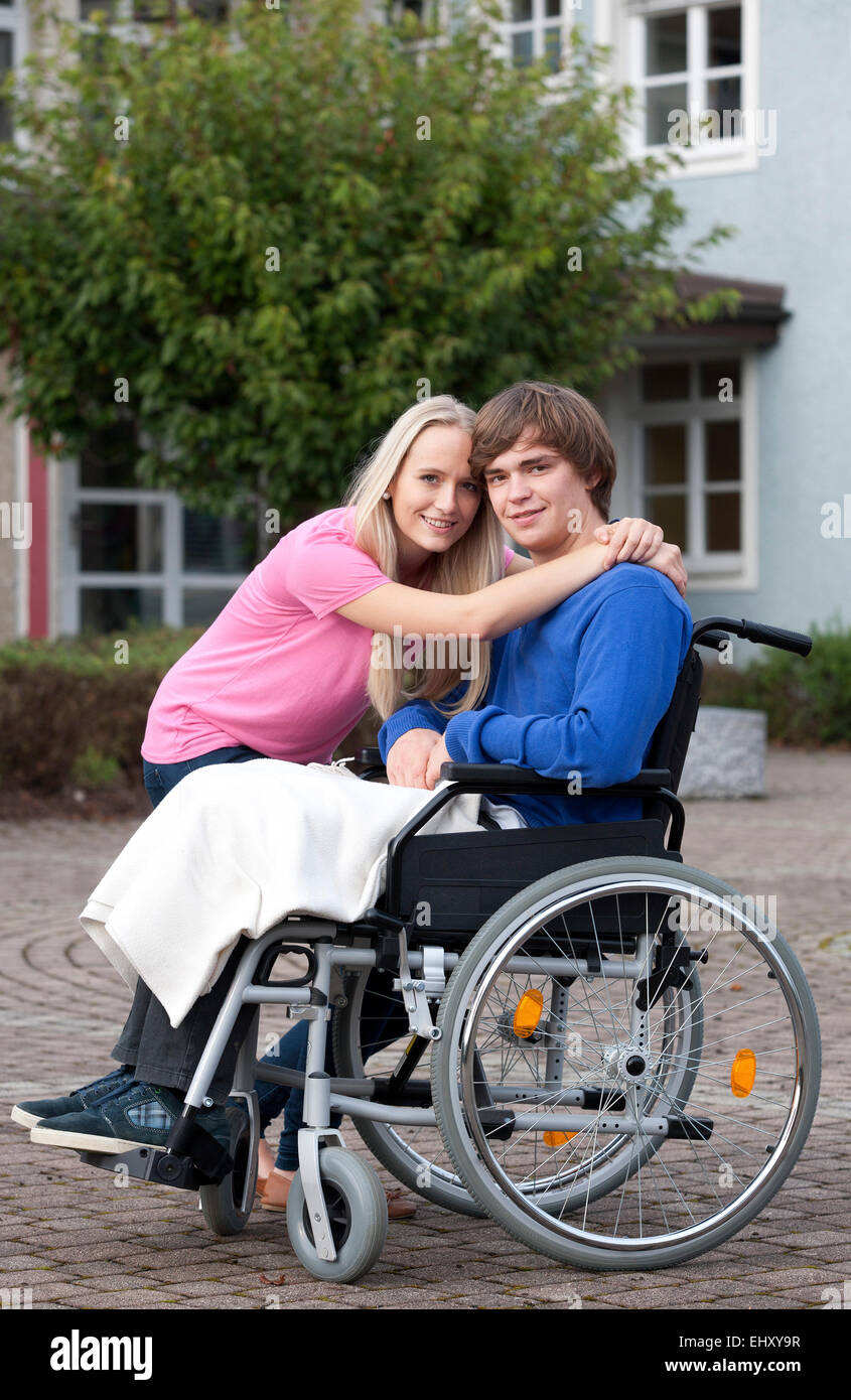 Young woman embracing her boyfriend sitting in wheelchair Stock Photo ...