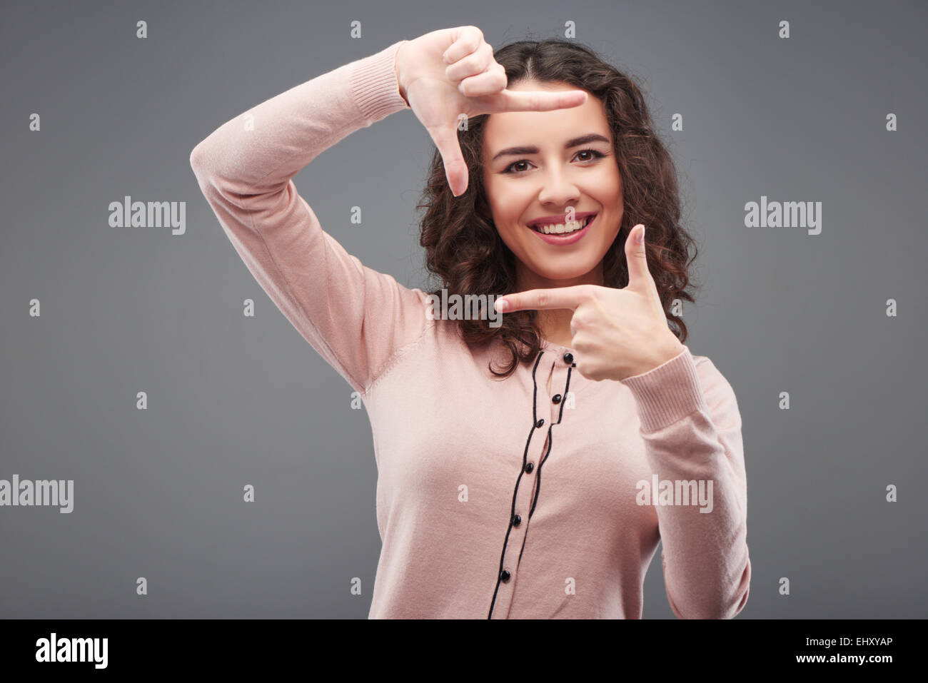 Smiling young woman making hand frame Stock Photo - Alamy