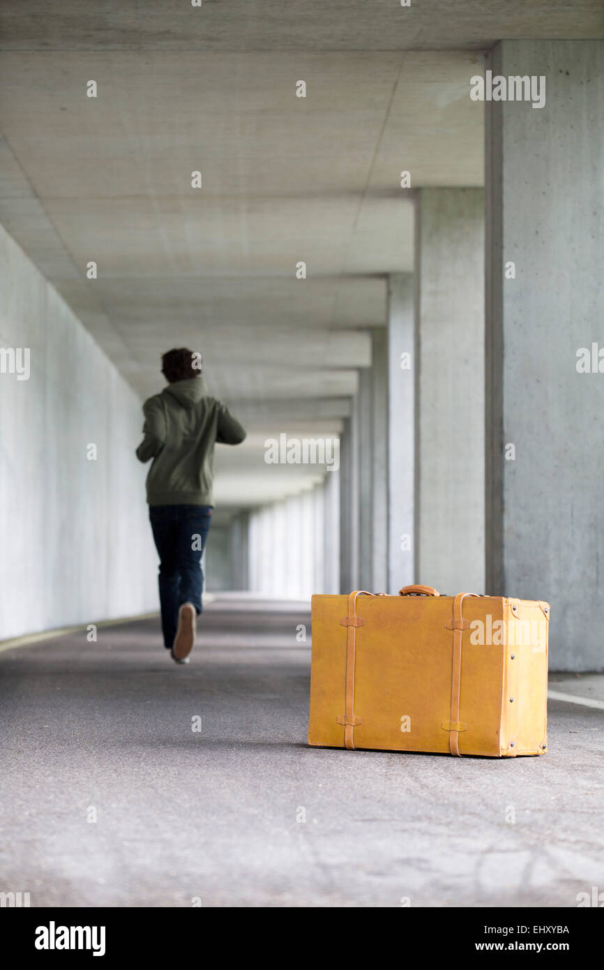 Running man and a leather suitcase in a car park Stock Photo - Alamy