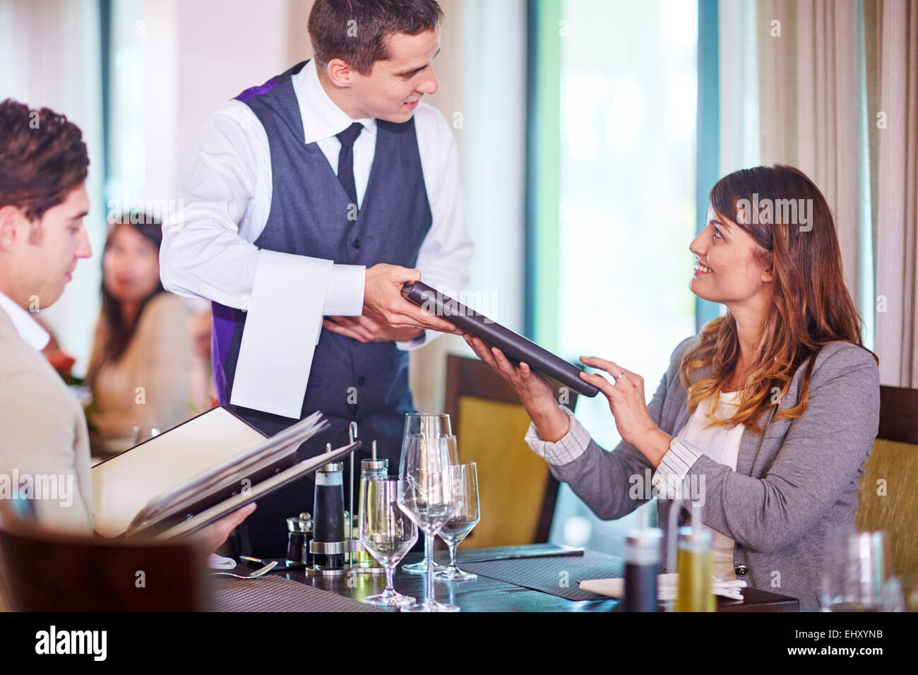 Business people placing an order with waiter at hotel restaurant Stock ...