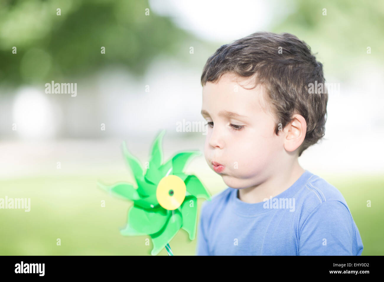 Portrait of little boy blowing paper windmill Stock Photo - Alamy
