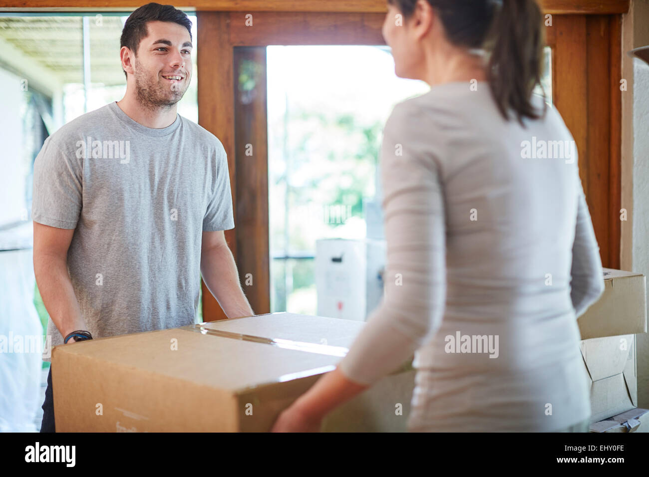 Couple moving house carrying a box Stock Photo - Alamy