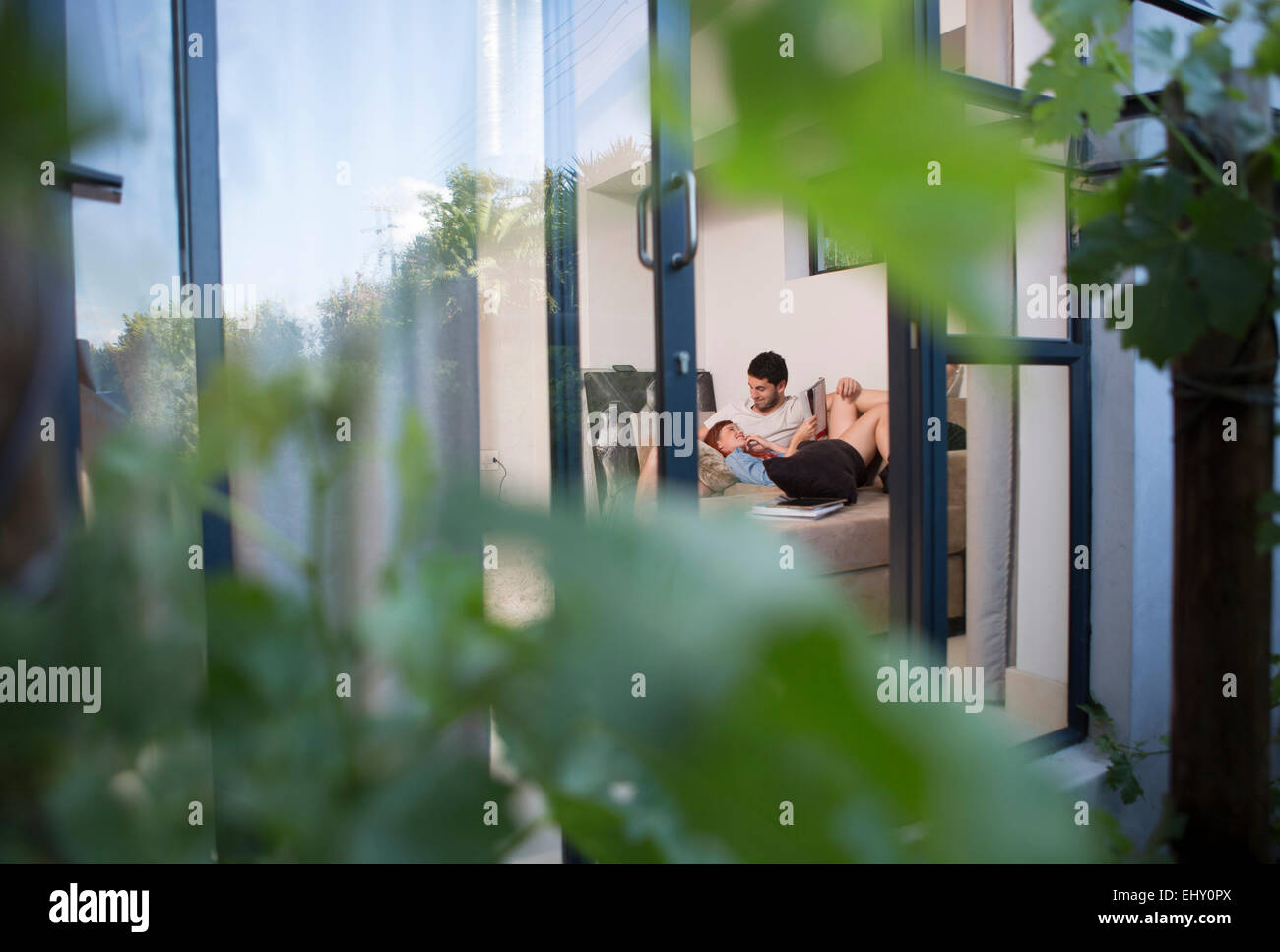 Couple relaxing together on a couch Stock Photo - Alamy