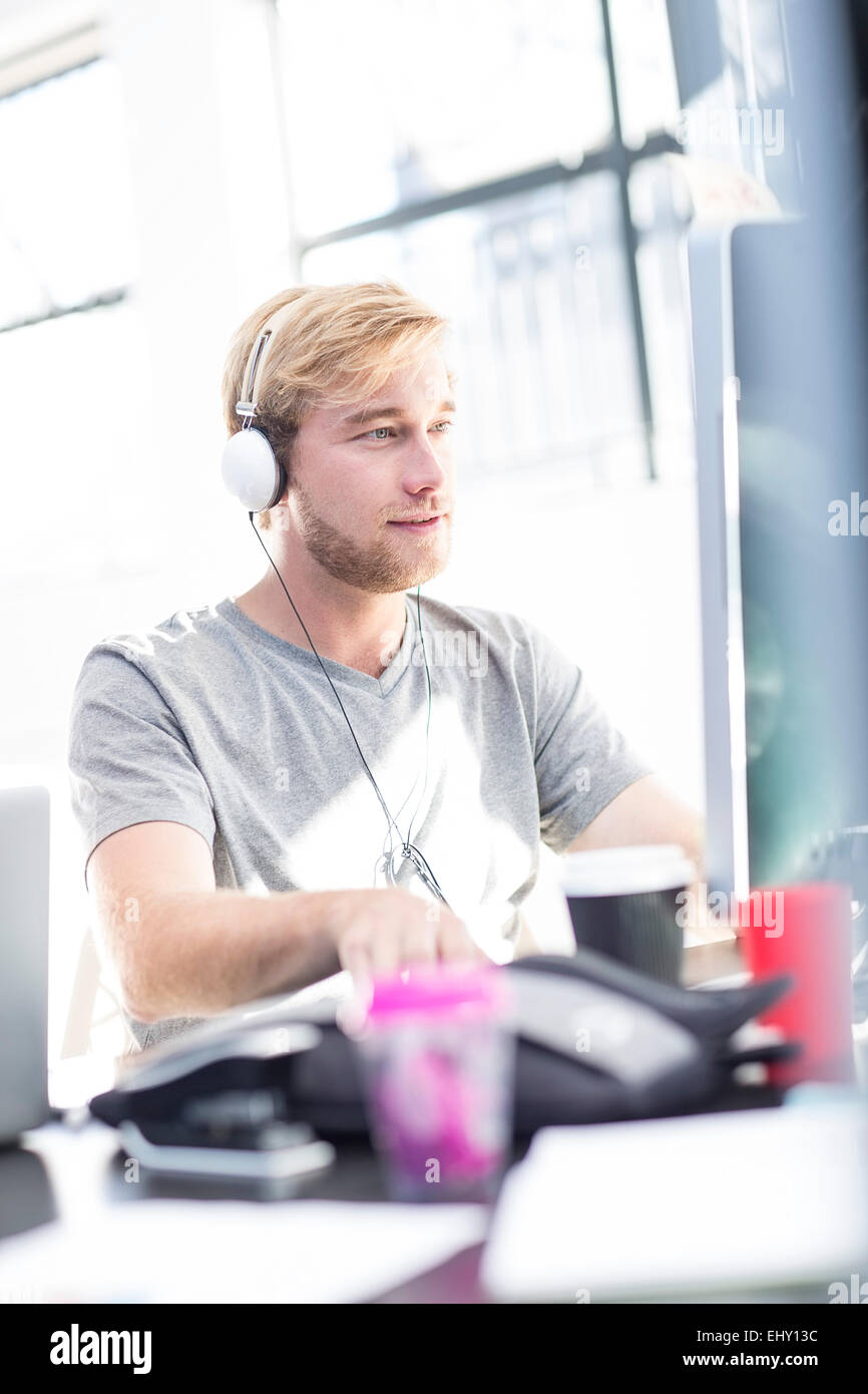 Creative office man working on his computer and wearing a headset Stock ...