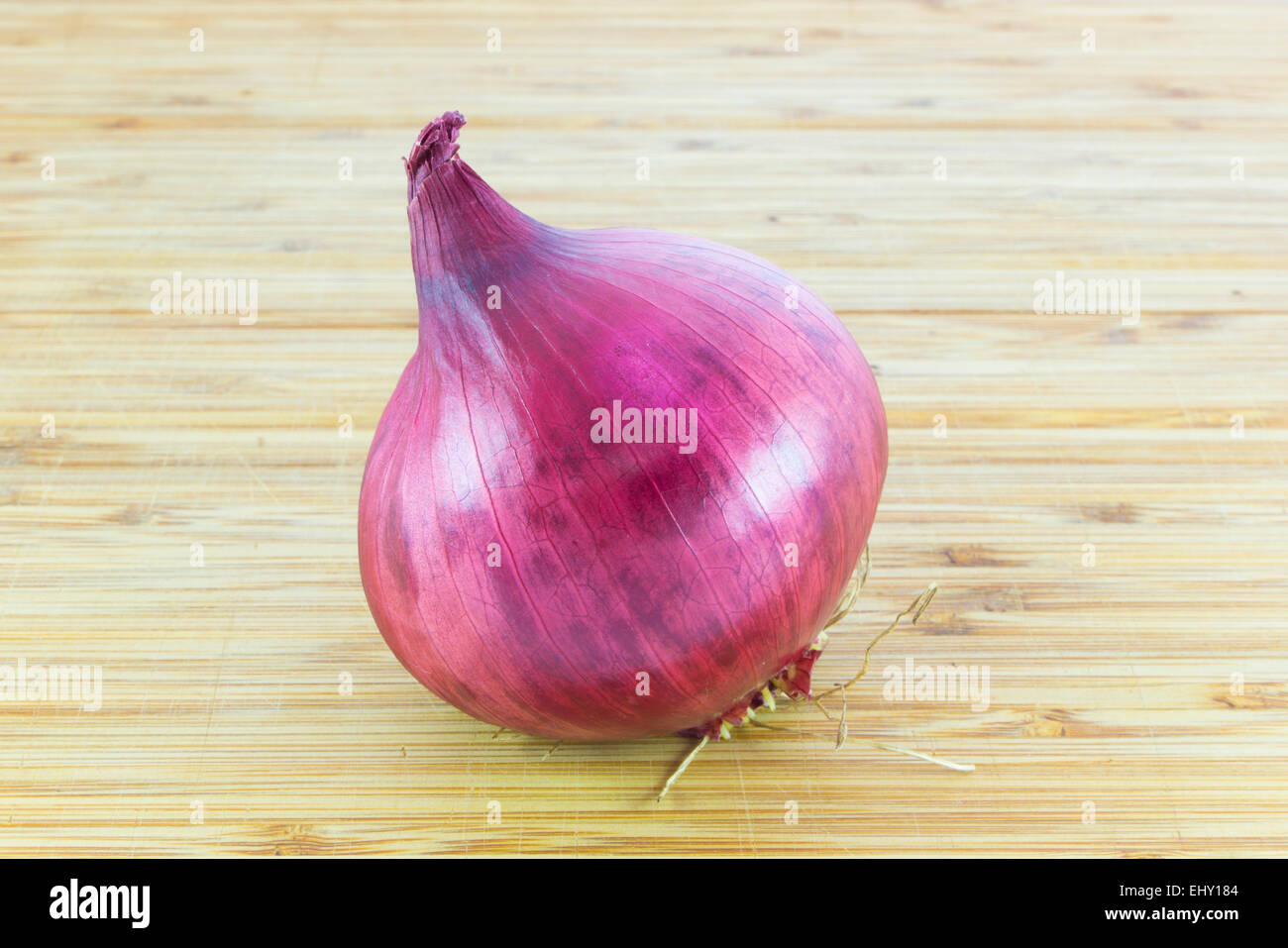 Single red onion on a wooden background Stock Photo - Alamy