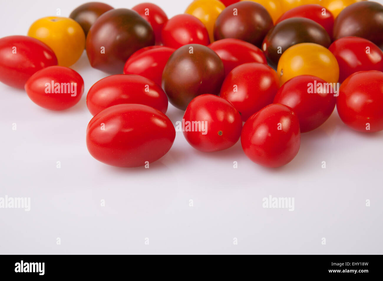 Handful of colorful cherry tomatoes. Isolated over white background ...