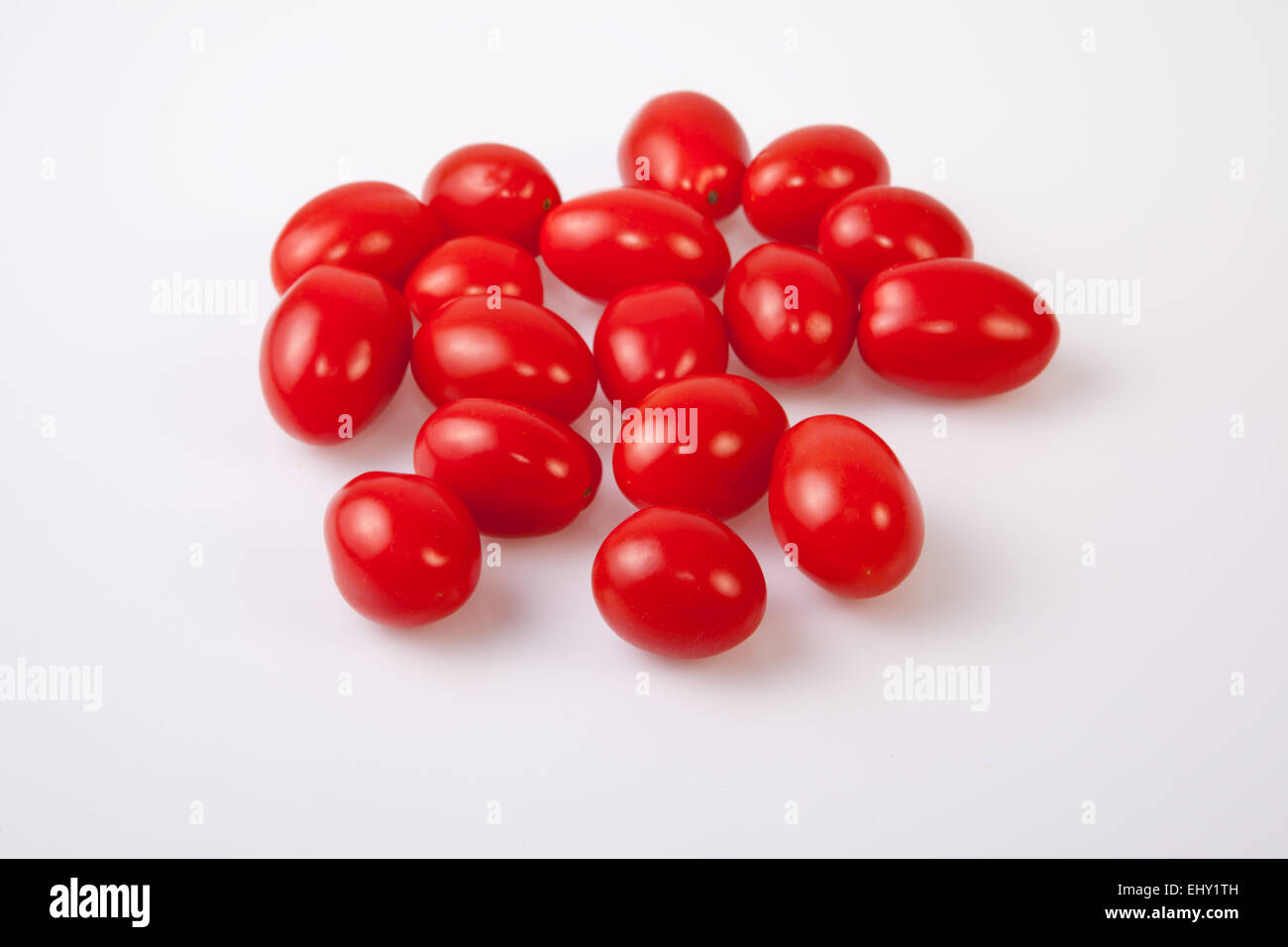 Handful of red shiny cherry tomatoes. Isolated over white background ...