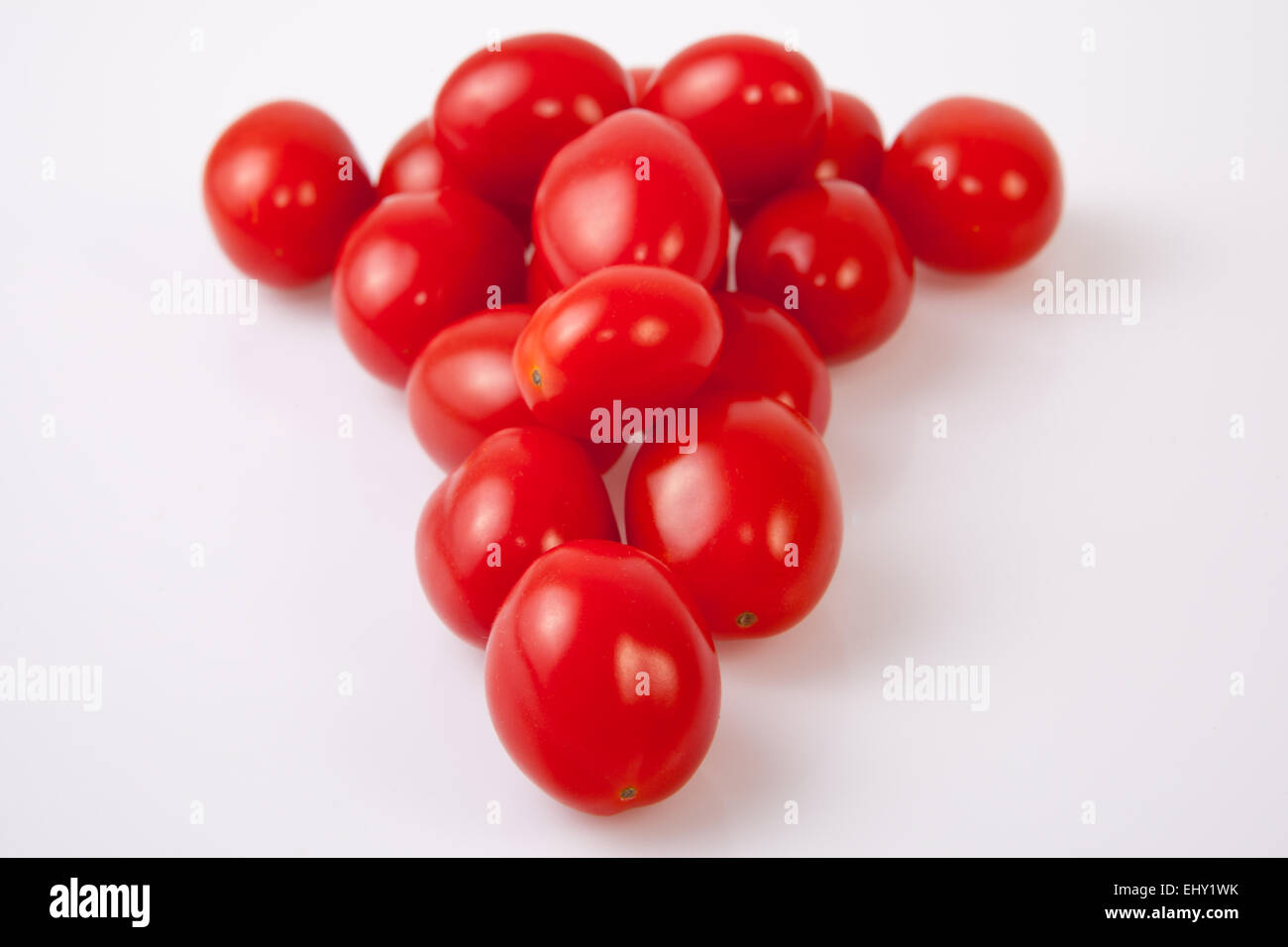 Handful of red shiny cherry tomatoes. Isolated over white background ...