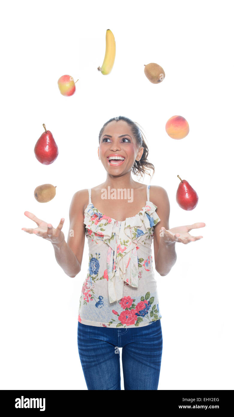 Mulatto person juggler with fruit in studio Stock Photo - Alamy