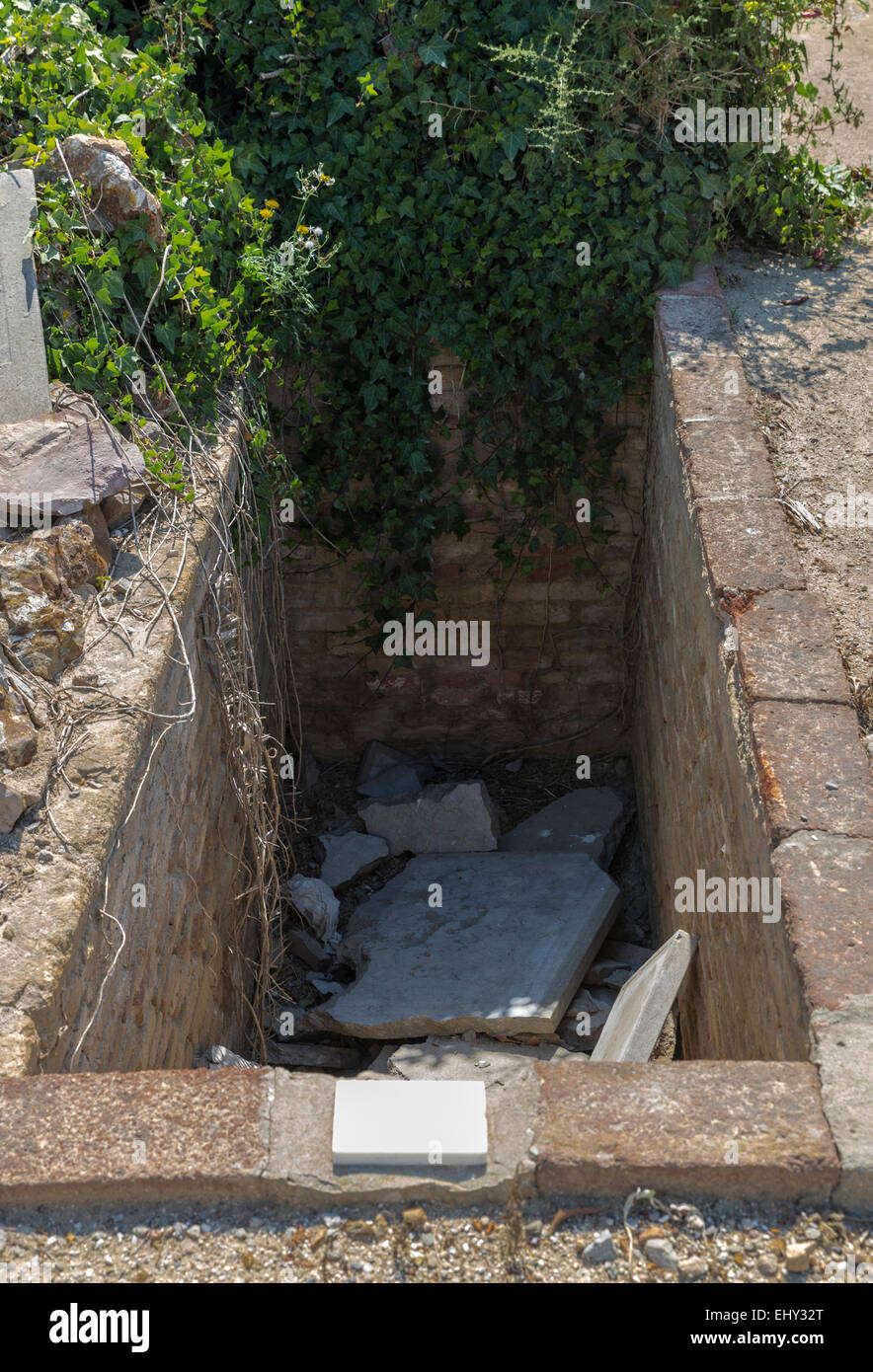 Open and empty tomb in a cemetery. The tomb is at ground level Stock ...