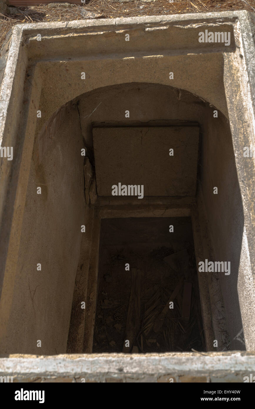 Open and empty tomb in a cemetery. The tomb is at ground level and has ...