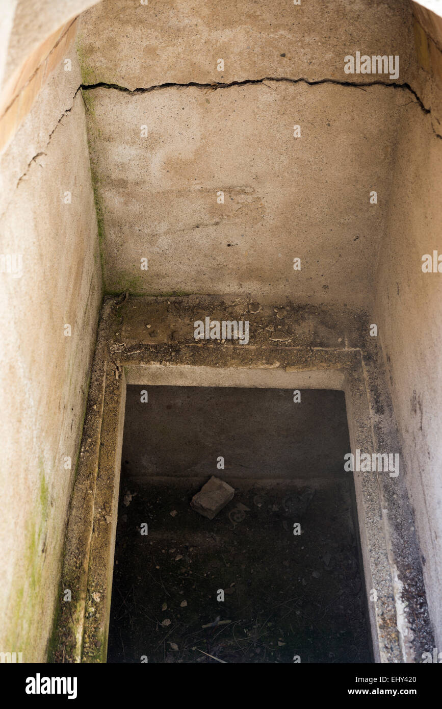 Open and empty tomb in a cemetery. The tomb is at ground level and has ...