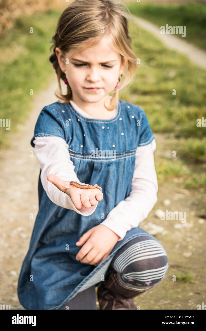 Girl holding worm in hand Stock Photo - Alamy