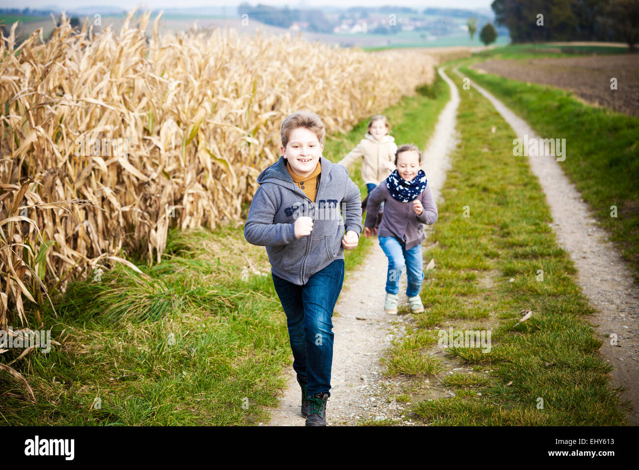 Three children running on path Stock Photo - Alamy