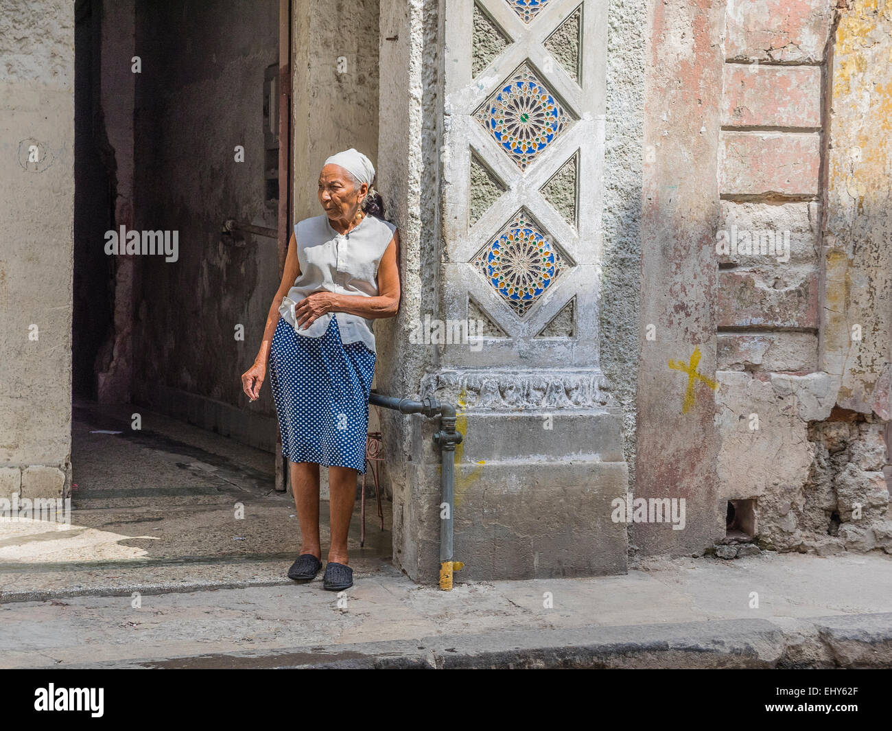 A Cuban senior citizen woman stands outside of her home in the historic ...