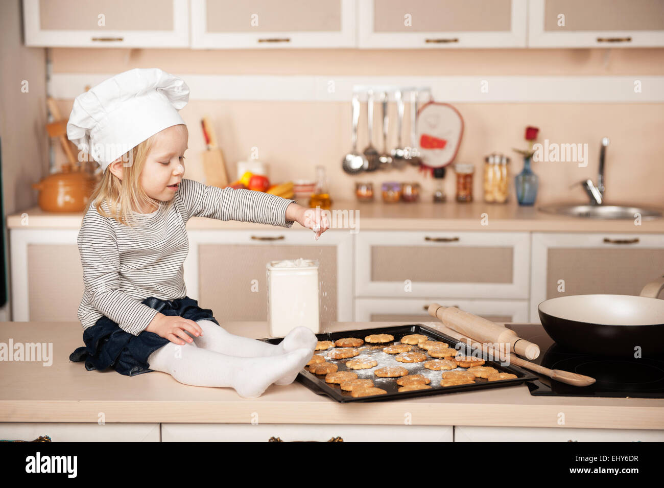 Little cute girl with chef hat preparing cookies in kitchen Stock Photo ...