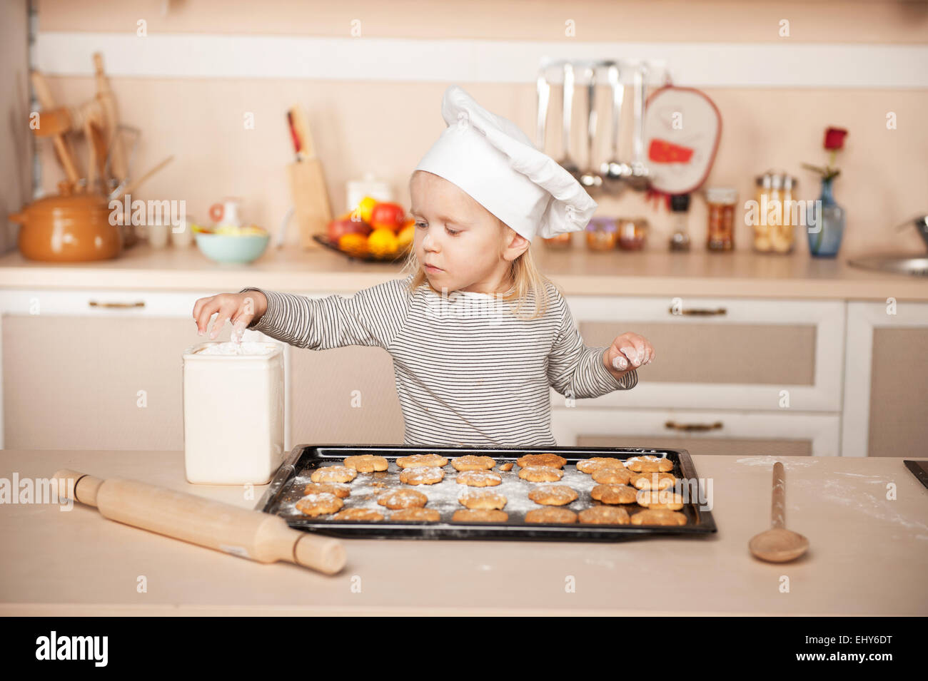 Cute girl with chef hat preparing cookies in kitchen Stock Photo - Alamy