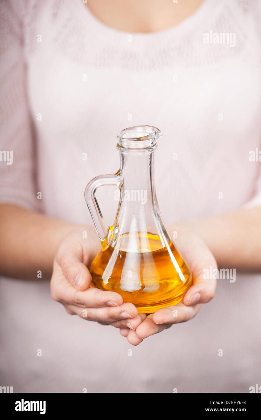 Close up photo of jug with oil in female hands Stock Photo - Alamy