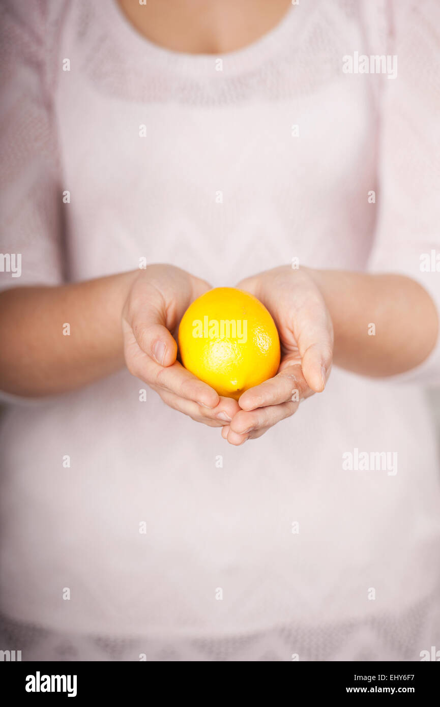 Close up photo of lemon in female hands Stock Photo - Alamy