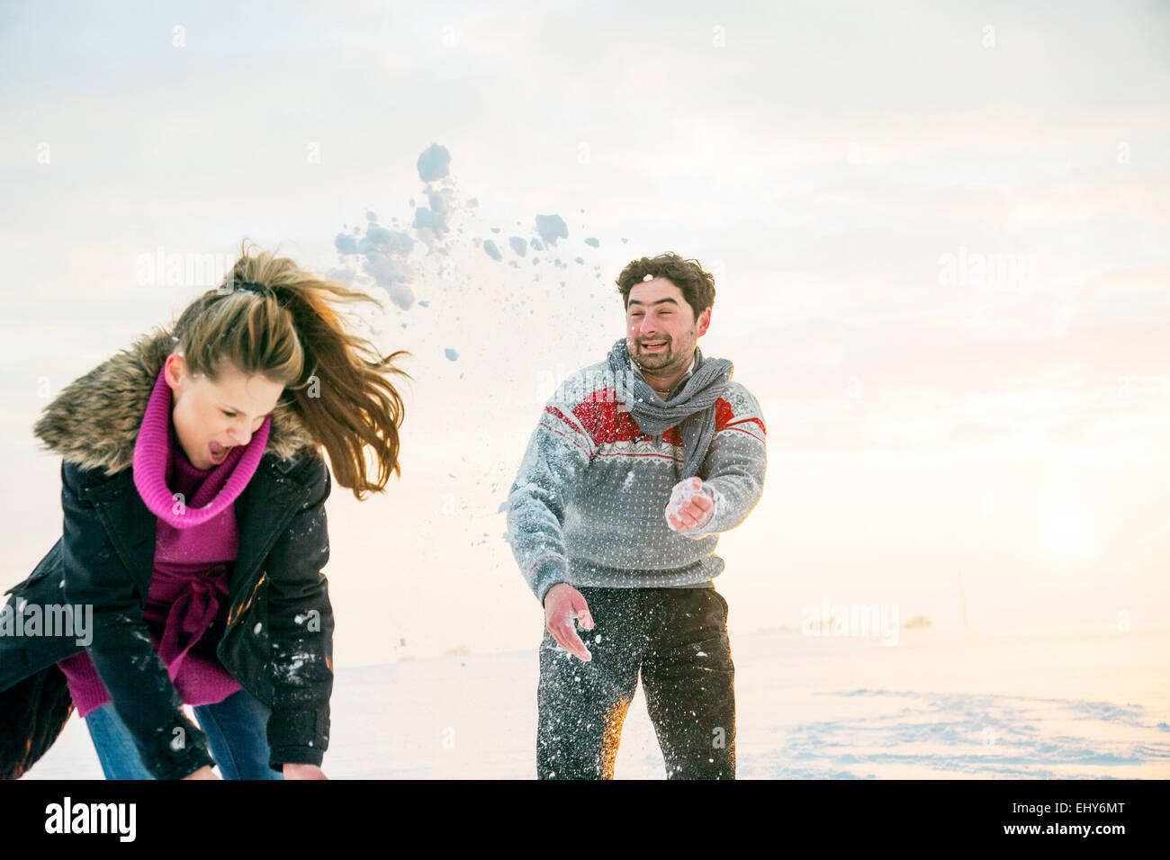 Couple having snowball fight Stock Photo - Alamy