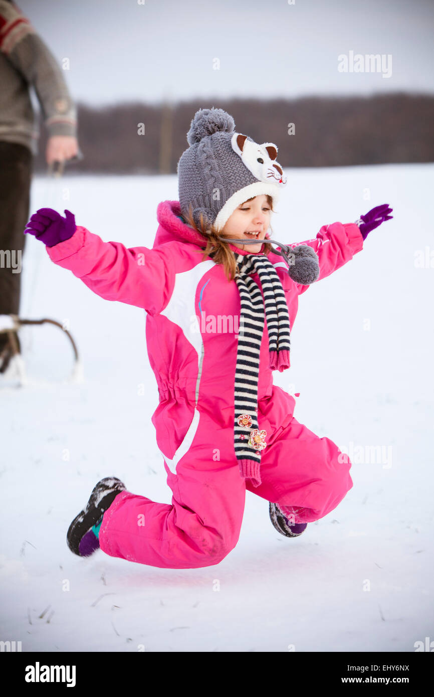 Girl jumping in snow Stock Photo - Alamy